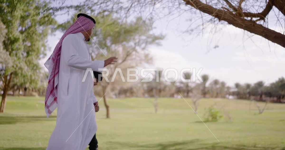 A Saudi Gulf Arab man spends fun times with his son, a tour in a public ...