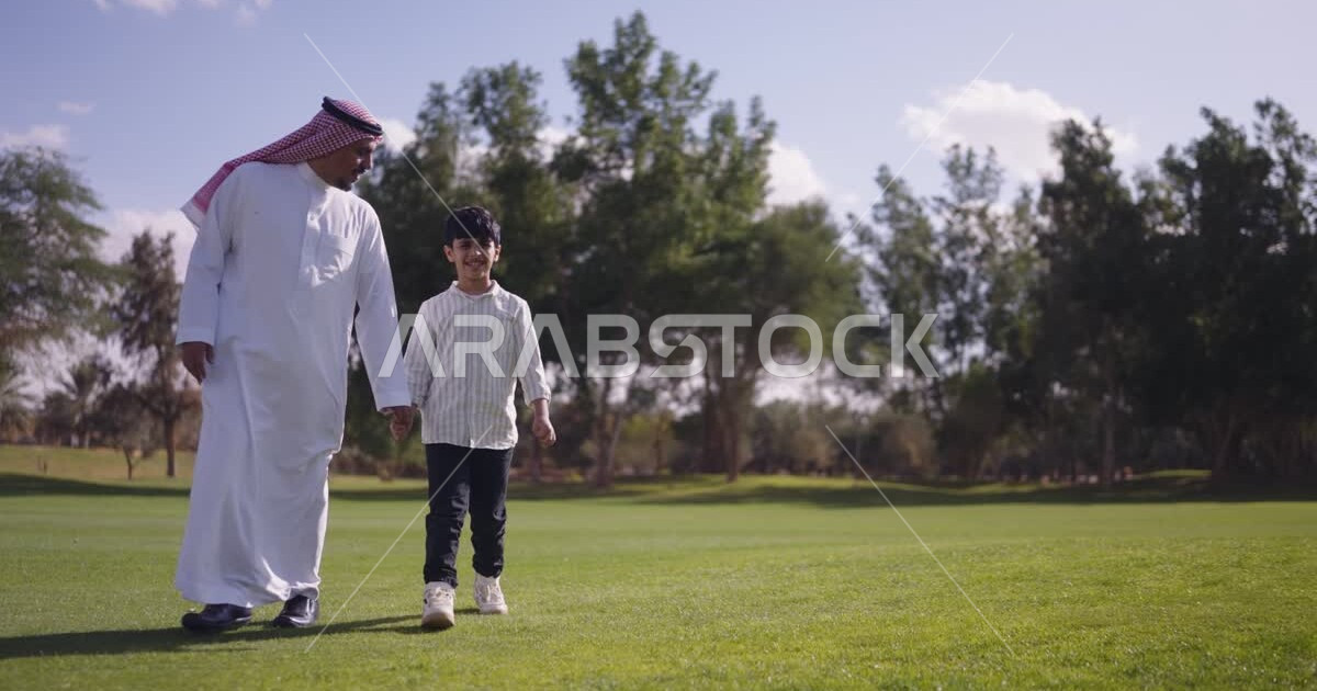 A Saudi Gulf Arab man spends fun times with his son, a tour in a public ...