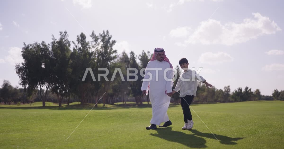 A Saudi Gulf Arab man spends fun times with his son, a tour in a public ...