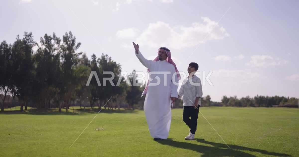 A Saudi Gulf Arab man spends fun times with his son, a tour in a public ...