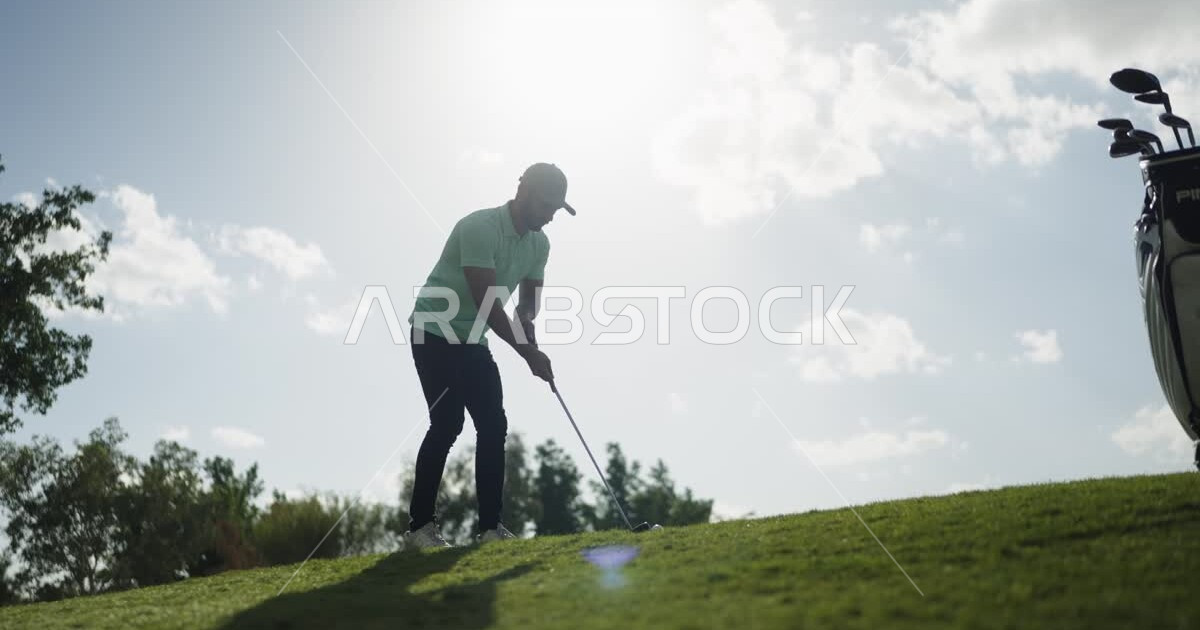 A Saudi Arabian Gulf man plays golf, wide green spaces, golf ball, golf ...