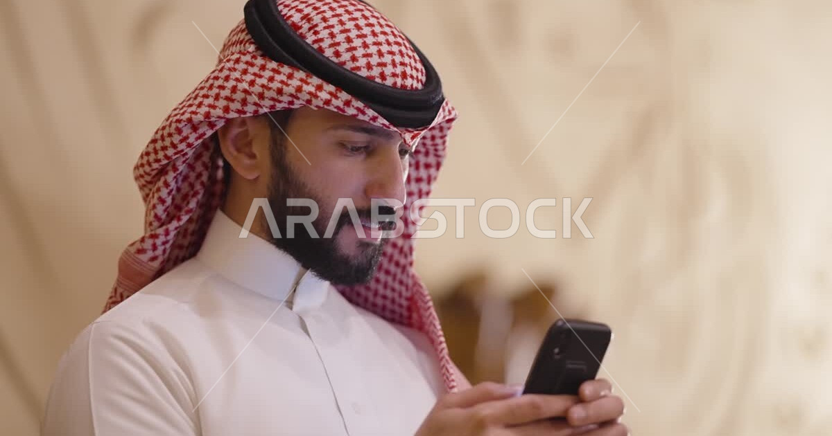 A Saudi Arabian Gulf man using a mobile phone, surfing the Internet ...