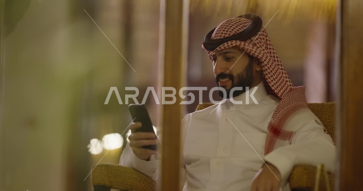 A Saudi Arabian Gulf man using a mobile phone, surfing the Internet ...