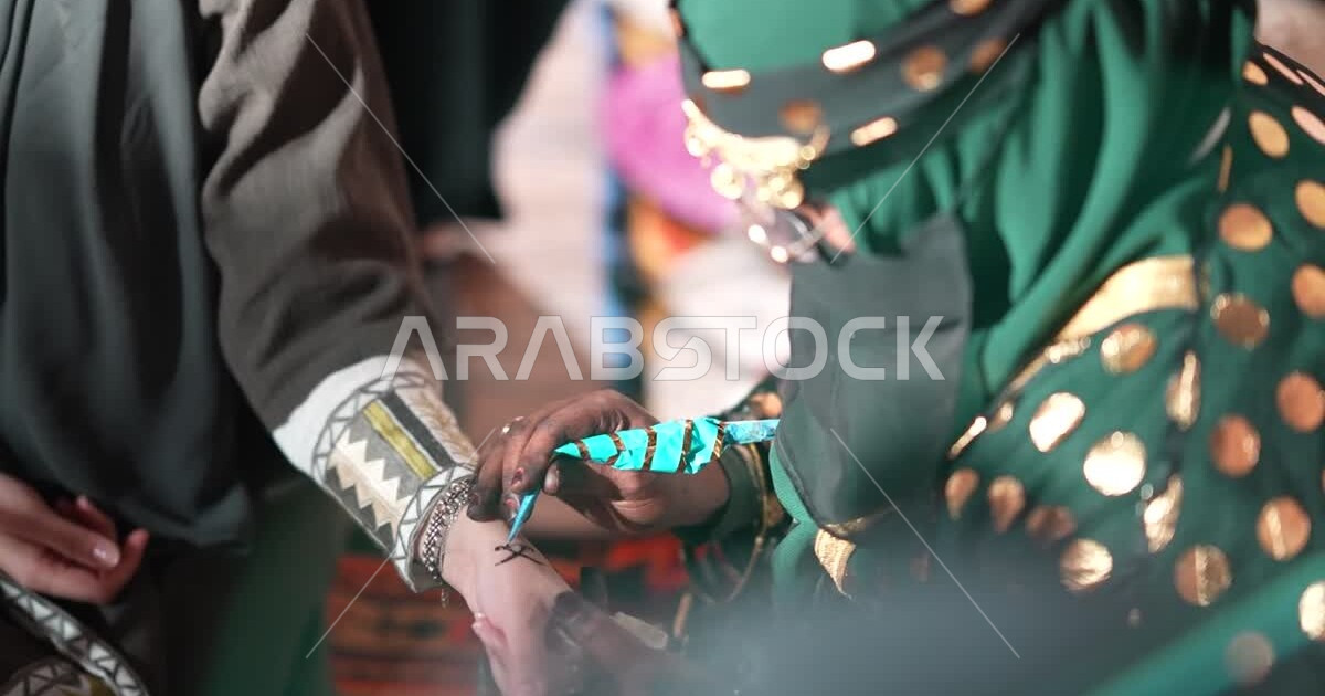 A Saudi Arab Gulf woman works with henna inscriptions, ancient ...