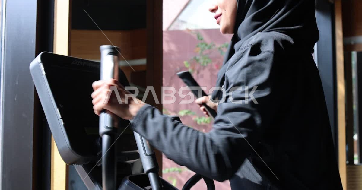 Saudi Gulf Arab woman, wearing sportswear, doing exercise in the club ...