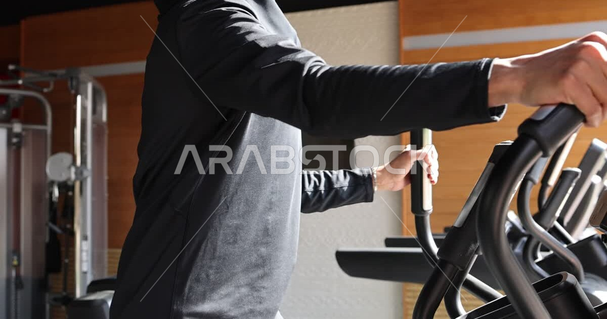 Saudi Gulf Arab woman, wearing sportswear, doing exercise in the club ...