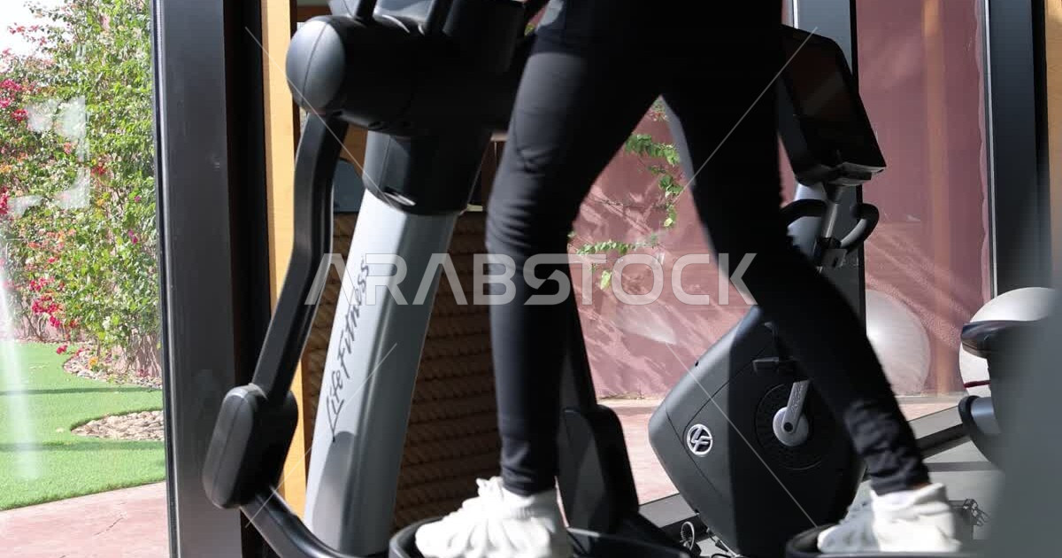 Saudi Gulf Arab woman, wearing sportswear, doing exercise in the club ...