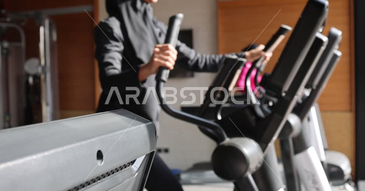 Saudi Gulf Arab woman, wearing sportswear, doing exercise in the club ...