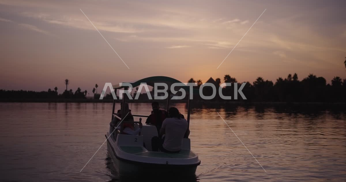 A Saudi Gulf Arab family on a boat tour in a water lake, leisure ...