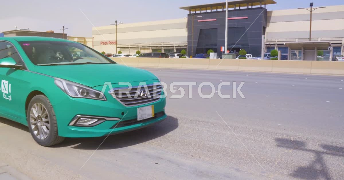 Green taxi in the streets of Saudi Arabia, taxi with modern tracking ...
