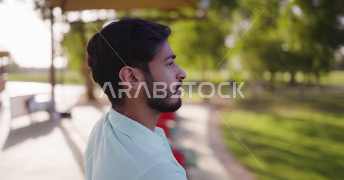 Close-up of a Saudi Arabian Gulf man, wearing a sports uniform, parks ...