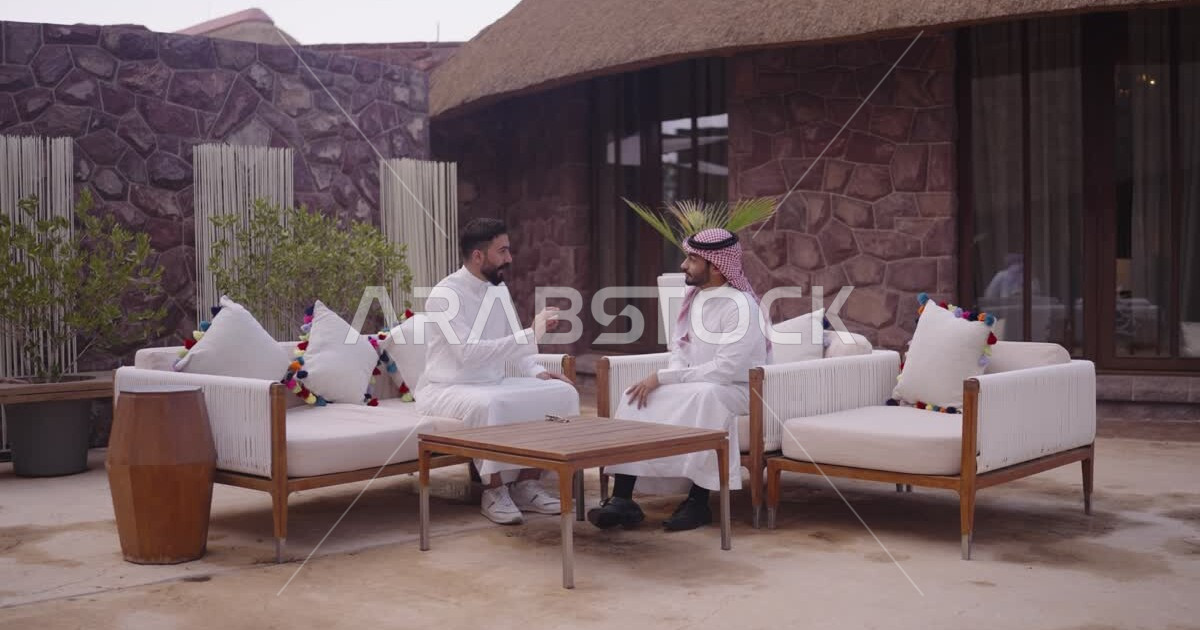 Two Saudi Arabian Gulf men in a tourist chalet in Saudi Arabia, outdoor ...