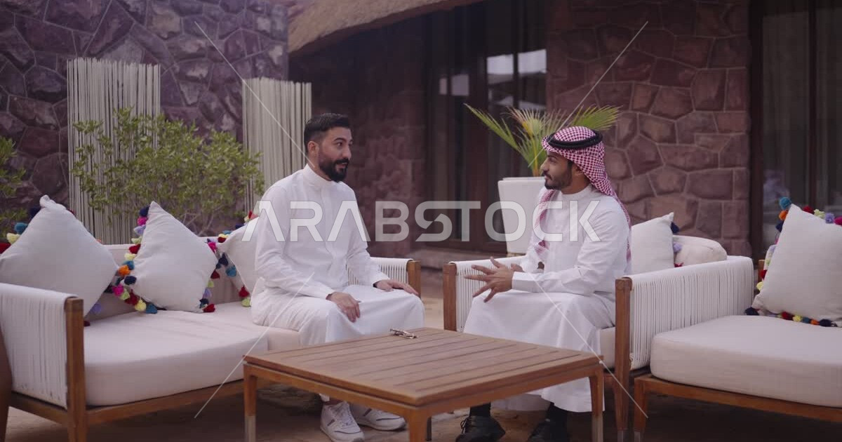 Two Saudi Arabian Gulf men in a tourist chalet in Saudi Arabia, outdoor ...