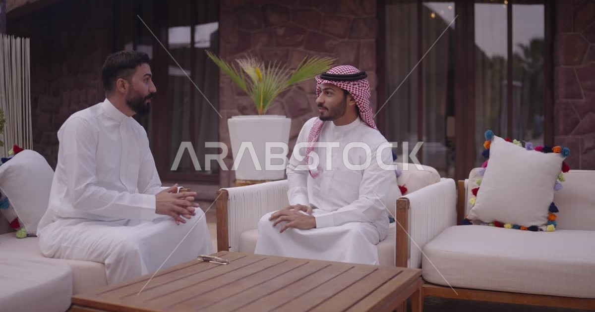Two Saudi Arabian Gulf men in a tourist chalet in Saudi Arabia, outdoor ...