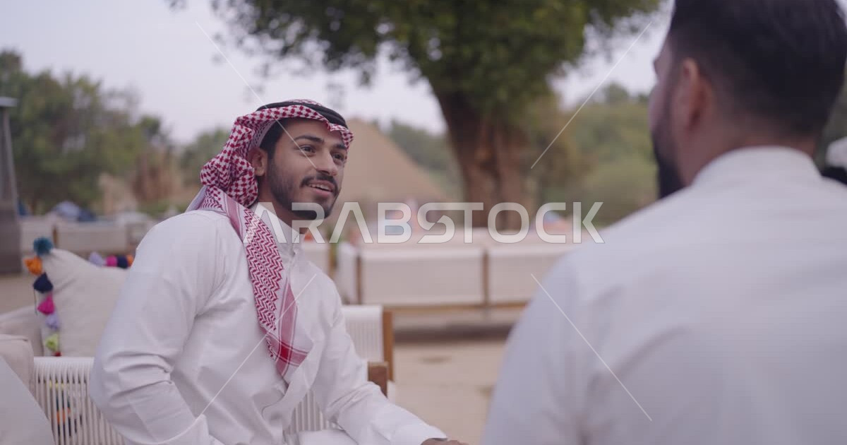 Two Saudi Arabian Gulf men in a tourist chalet in Saudi Arabia, outdoor ...