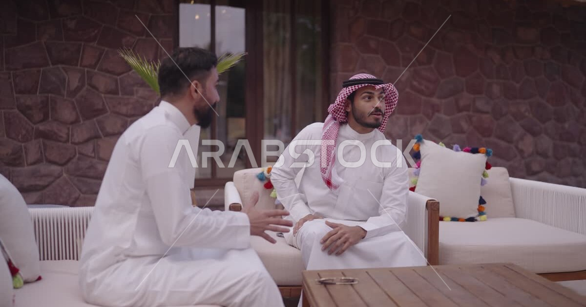 Two Saudi Arabian Gulf men in a tourist chalet in Saudi Arabia, outdoor ...