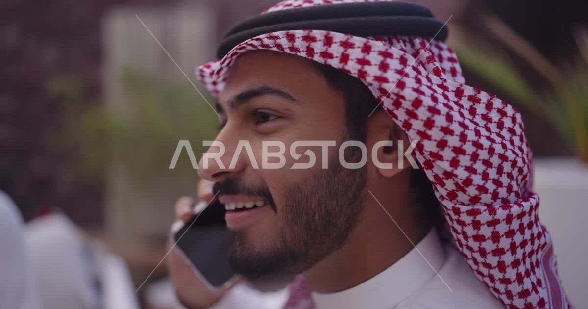 A Saudi Gulf Arab man, making a phone call using a mobile phone ...