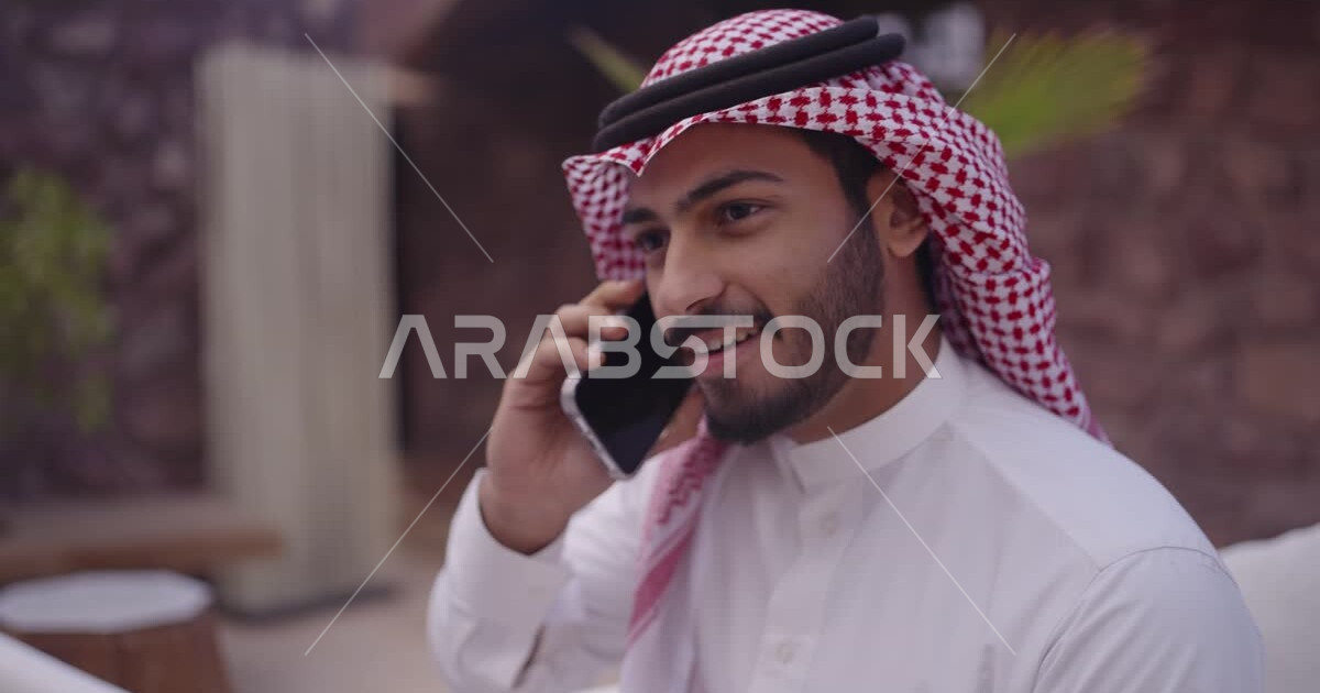 A Saudi Gulf Arab man, making a phone call using a mobile phone ...