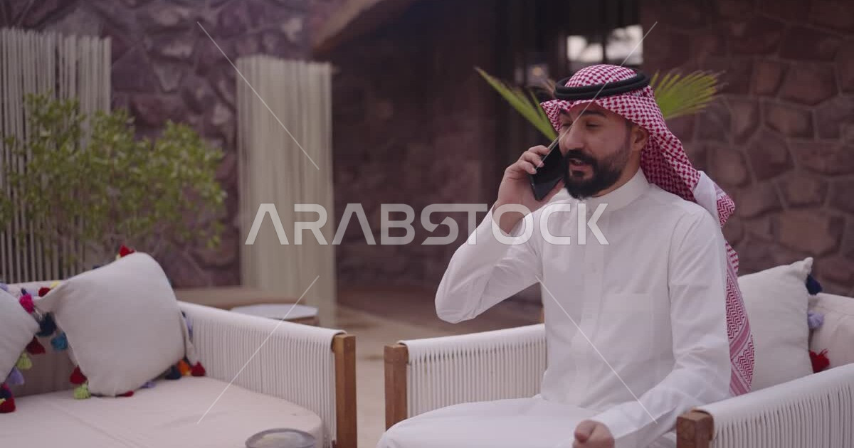 A Saudi Gulf Arab man, making a phone call using a mobile phone ...