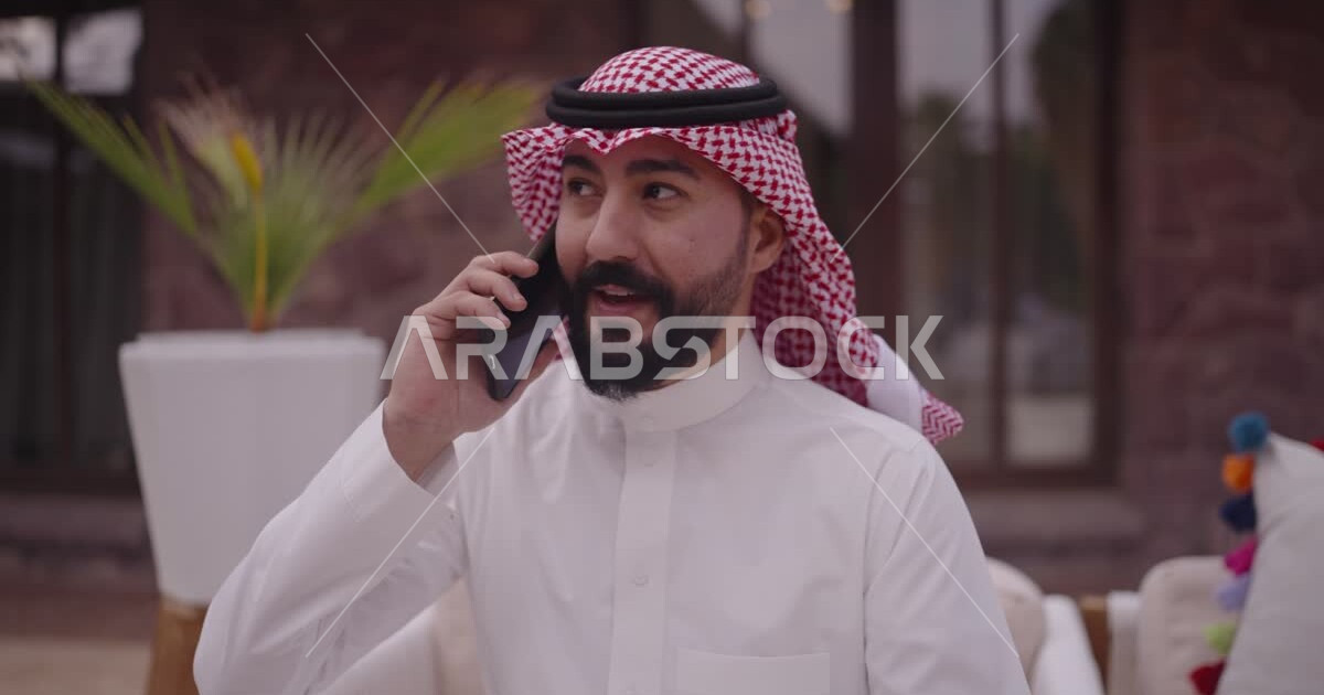 A Saudi Gulf Arab man, making a phone call using a mobile phone ...