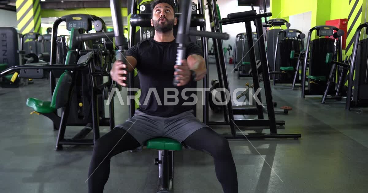 A young Saudi Arabian Gulf man exercising the chest muscle, a Saudi ...