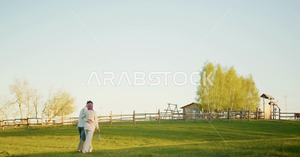 A young Arab couple enjoying a walk in the park, wandering in the open ...