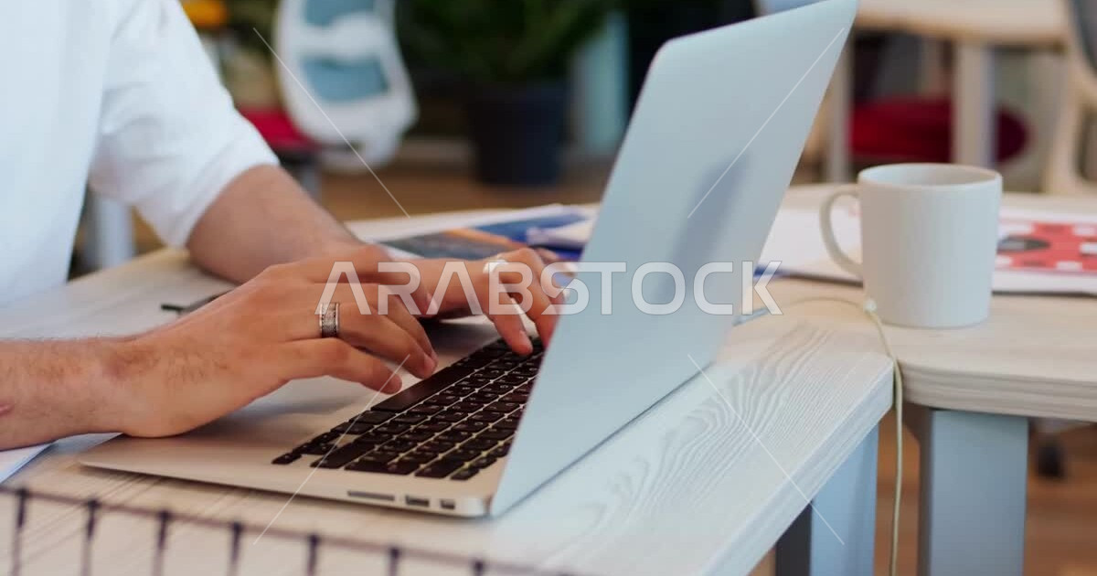 Man typing on laptop, company office, using laptop, working session ...