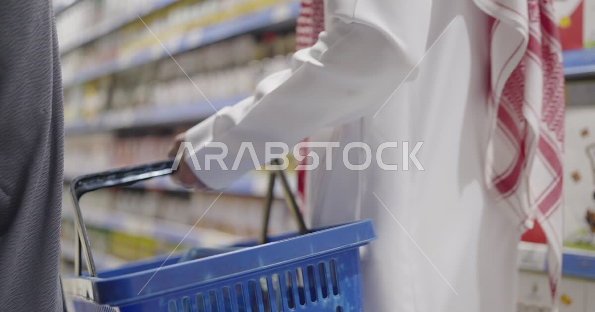 A Saudi Arabian Gulf couple shopping in the supermarket, commercial ...