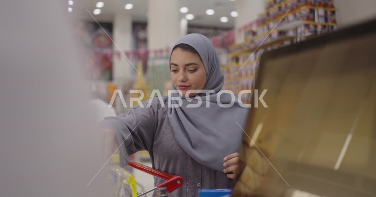 Close-up of a veiled Saudi Arabian Gulf woman in the supermarket ...