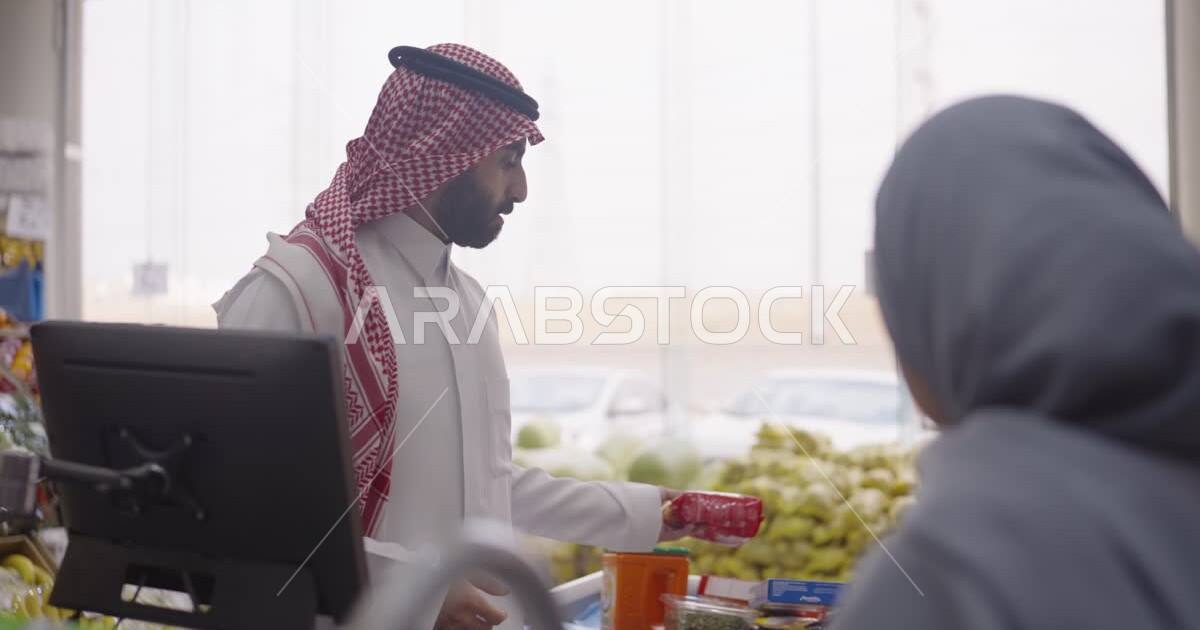 A Saudi Arab Gulf woman in the supermarket, verifying the value of ...