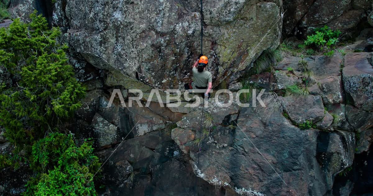 A picture from above of a Saudi Arabian Gulf man climbing the Al-Suda ...
