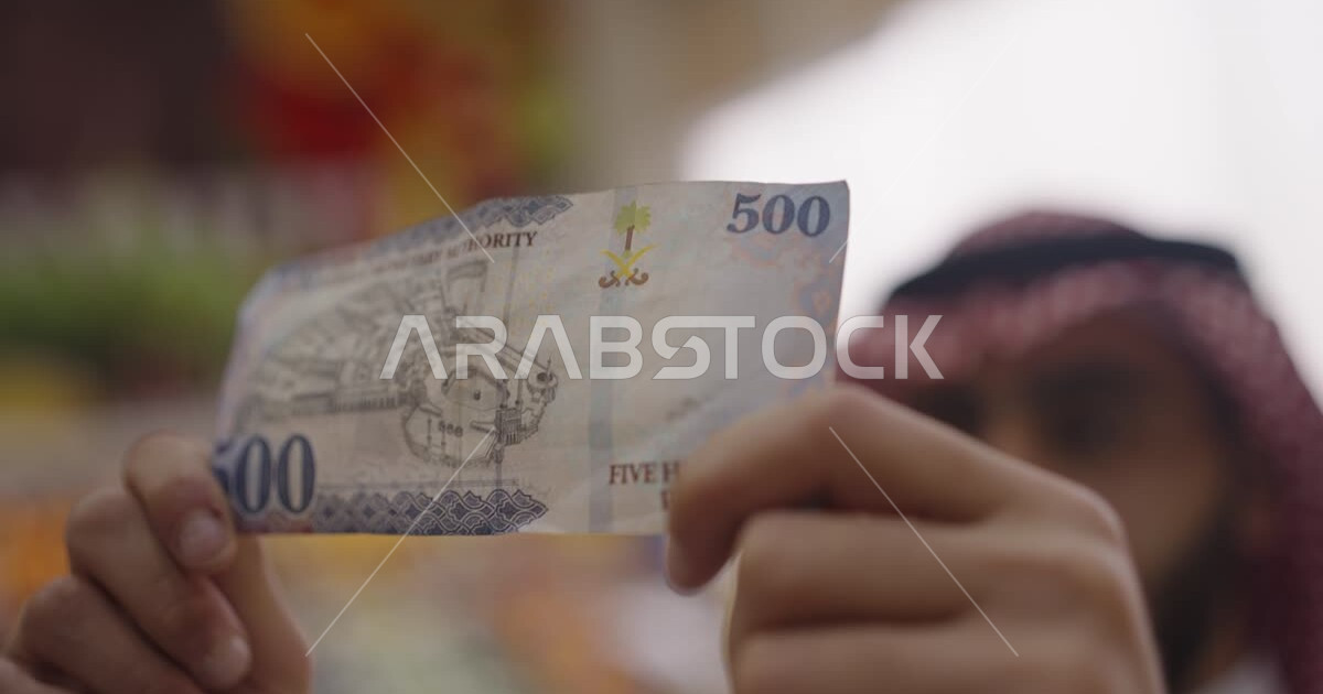 Close-up of the hand of a Saudi Arabian Gulf accountant holding ...