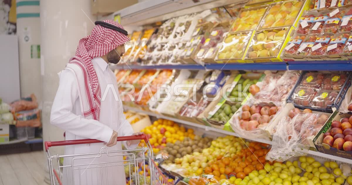 A Saudi Arabian Gulf man shopping in the fruit section of the ...