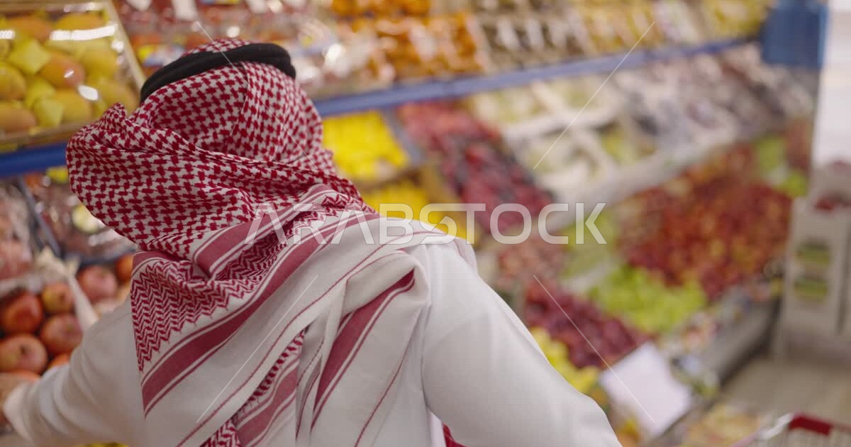 A Saudi Arabian Gulf man shopping in the fruit section of the ...