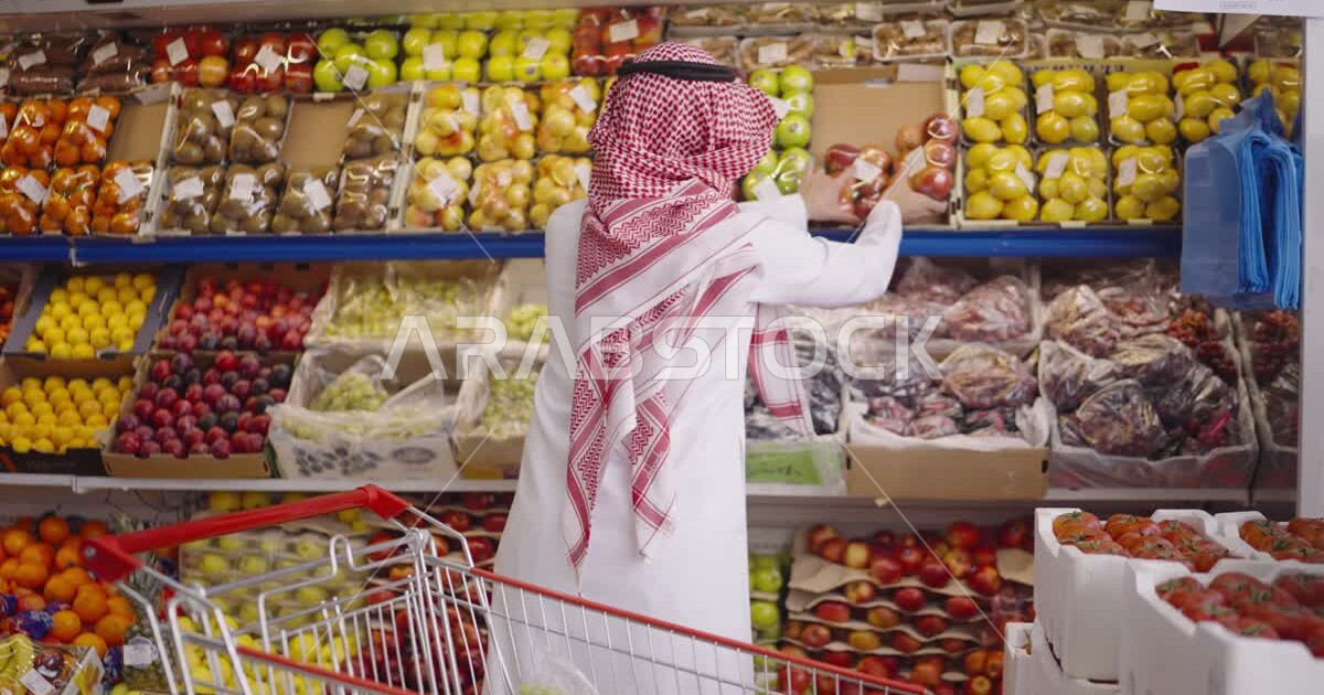 A Saudi Arabian Gulf man buys fruits from the supermarket, purchase of ...