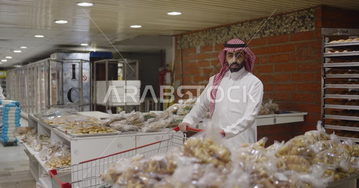 A Saudi Arabian Gulf man buys baked goods from the supermarket, the ...