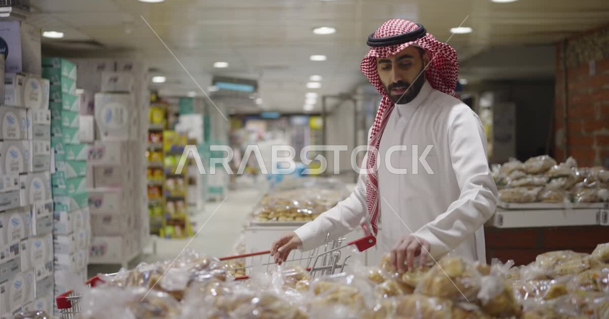 A Saudi Arabian Gulf man buys baked goods from the supermarket ...