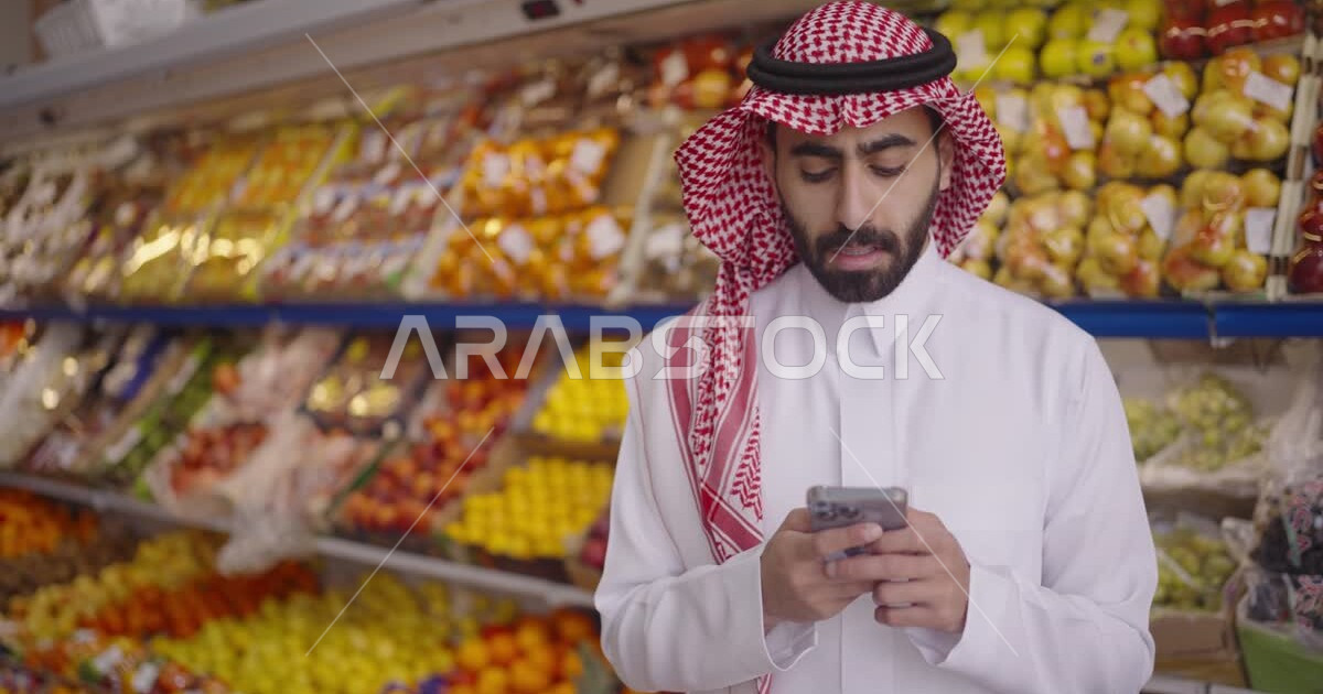 A Saudi Arabian Gulf man shopping in the fruit section of the ...