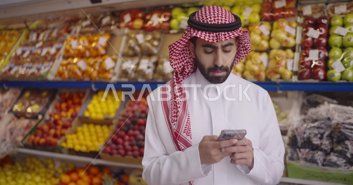 A Saudi Arabian Gulf man shopping in the fruit section of the ...