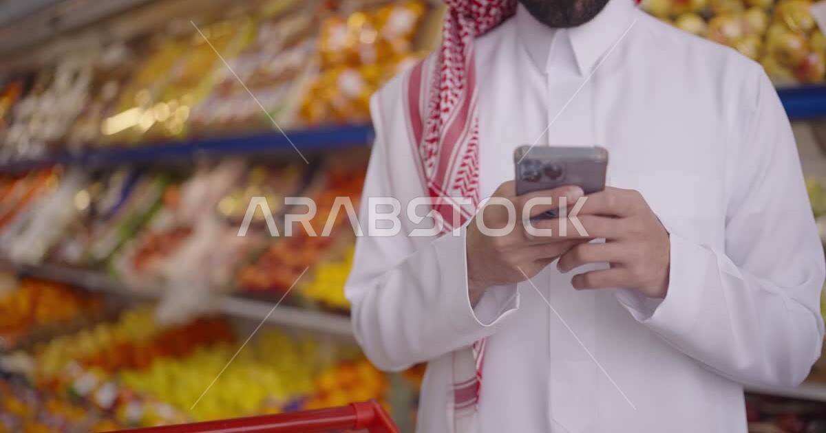Close-up of a Saudi Arabian Gulf man shopping in the fruit section in ...